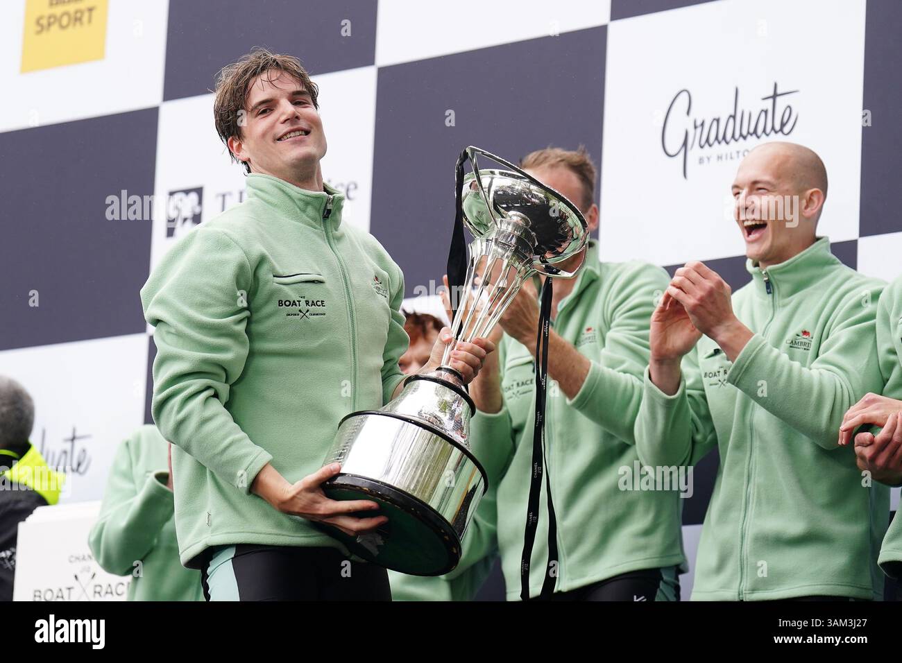 Cambridge Men's President Luca Ferraro lifts the trophy as they ...
