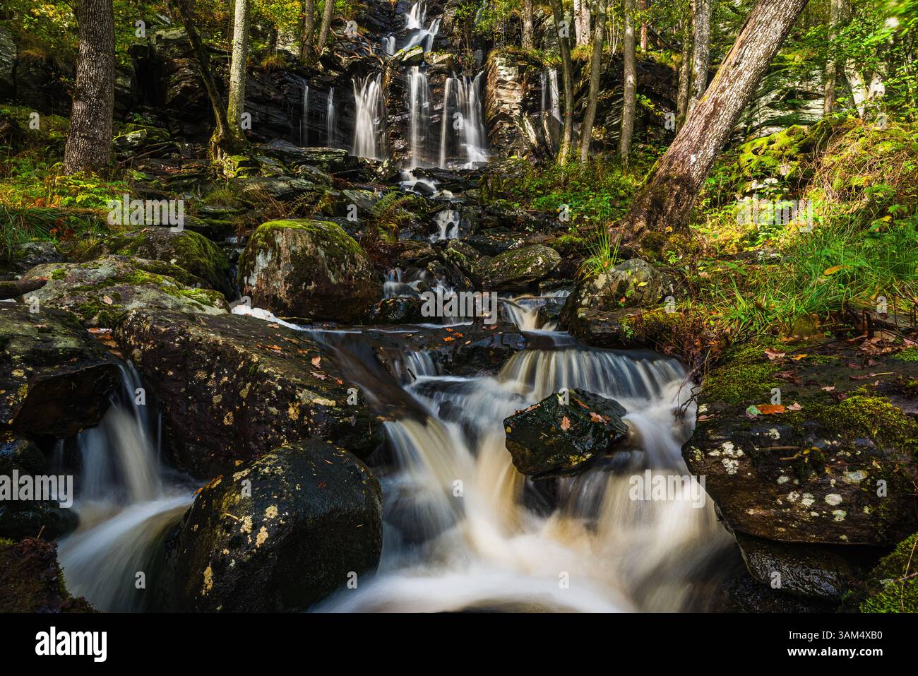 Water rushes over rocks, creating a beautiful waterfall in Sweden. The ...