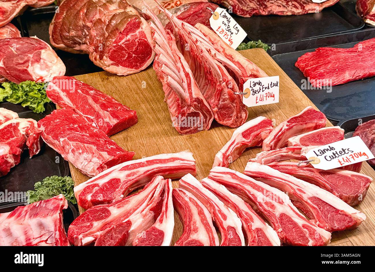 Selection of joints of fresh lamb on a butcher's stall in a market. No ...