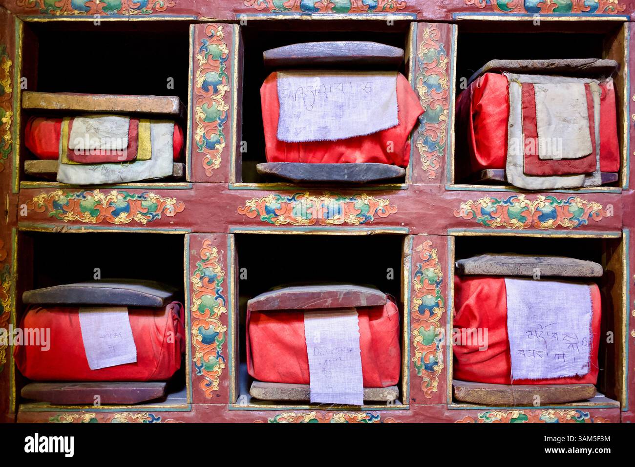 Tibetan Buddhist scriptures wrapped in cloth and stored in a painted ...
