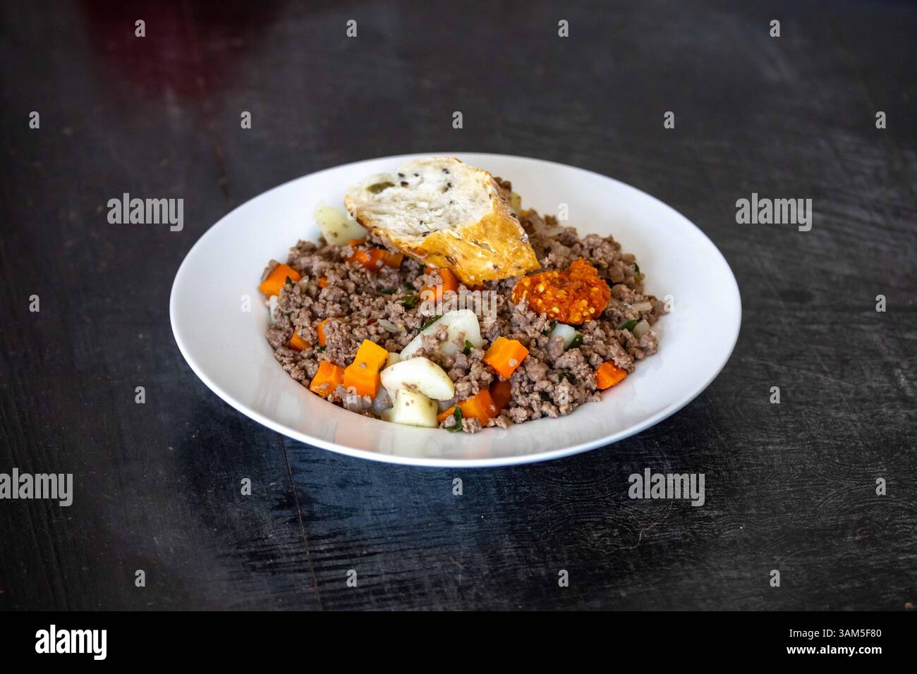 Traditional dish with ground beef and vegetables on an old plate and ...