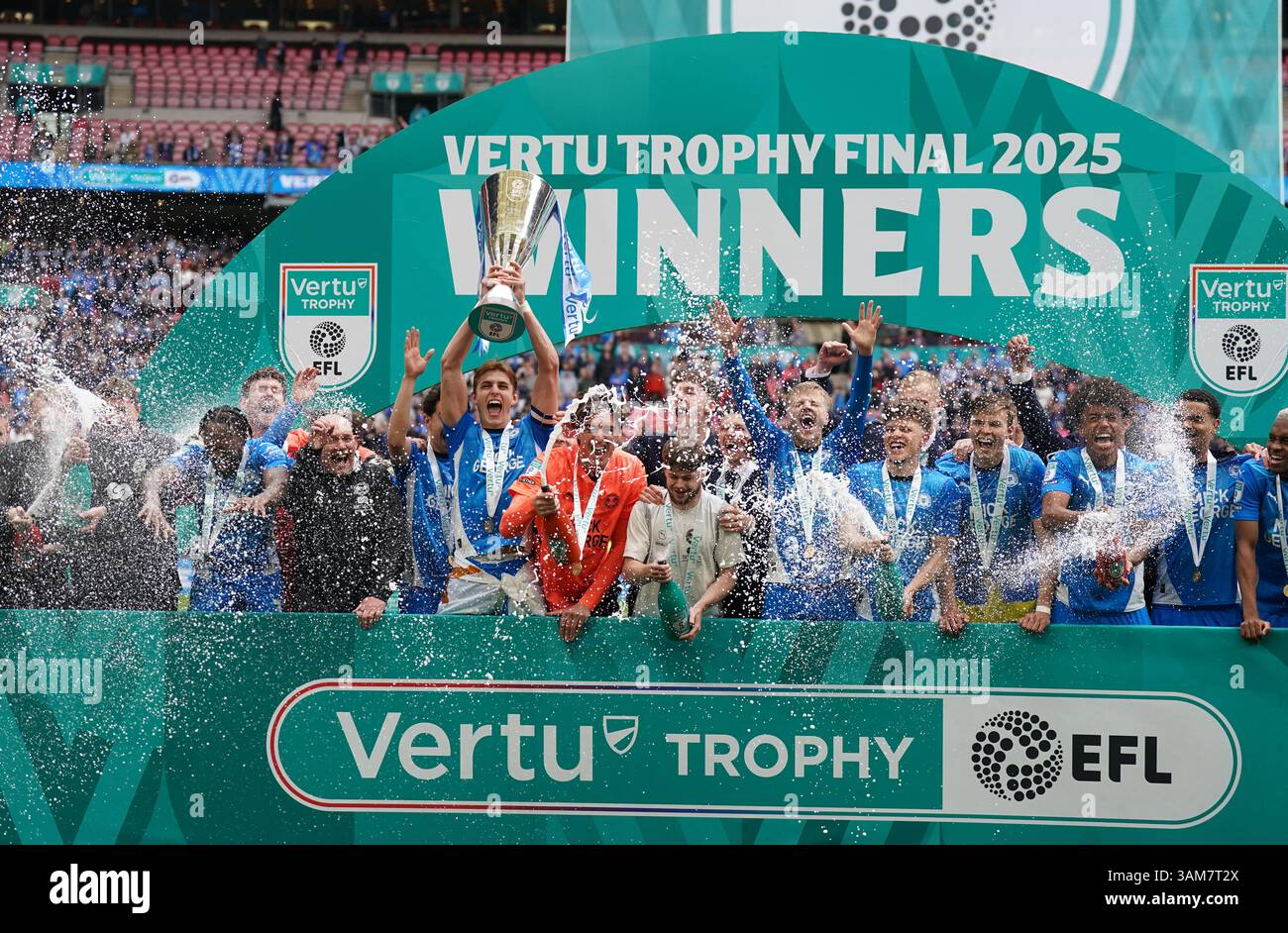Peterborough United's Hector Kyprianou lifts the trophy after winning ...