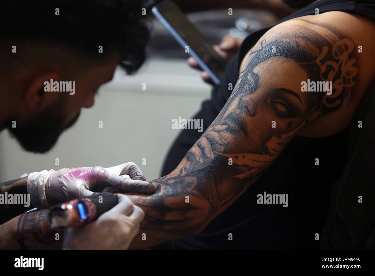 Kathmandu, Nepal. April 13, 2025: A tattoo artist inks a customer ...