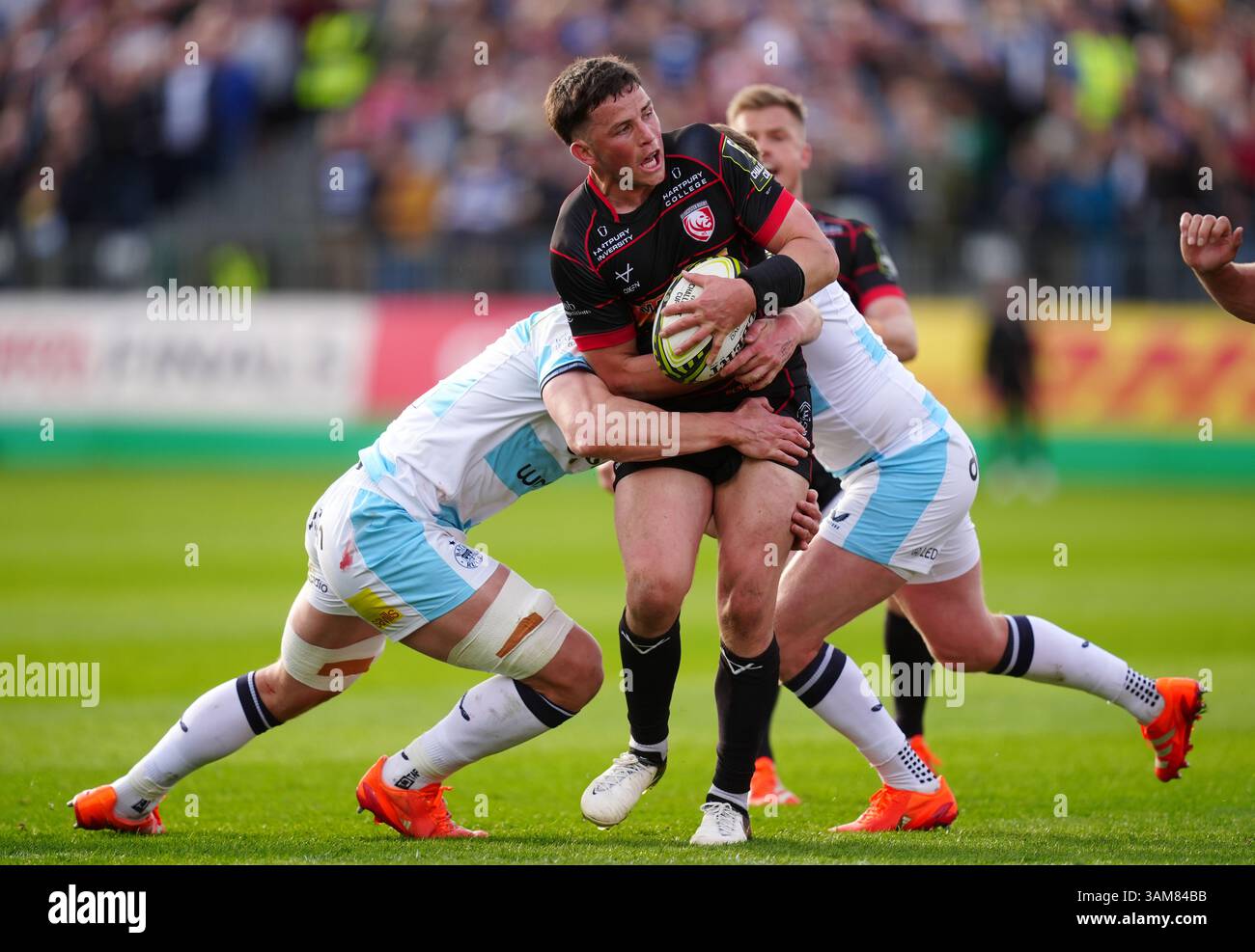 Gloucester's Will Butler (centre) tackled by Bath's Ted Hill (left) and ...