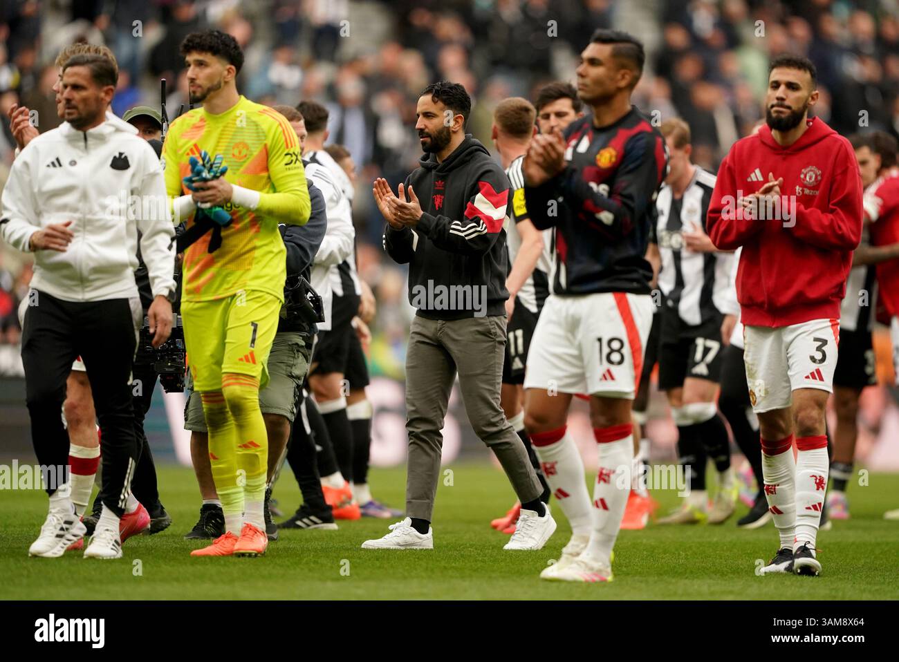 Manchester United manager Ruben Amorim (centre) applauds the fans after ...
