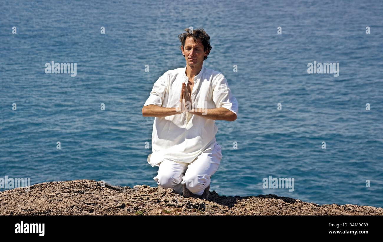 Yoga posture on the rocks at the atlantic ocean Stock Photo - Alamy