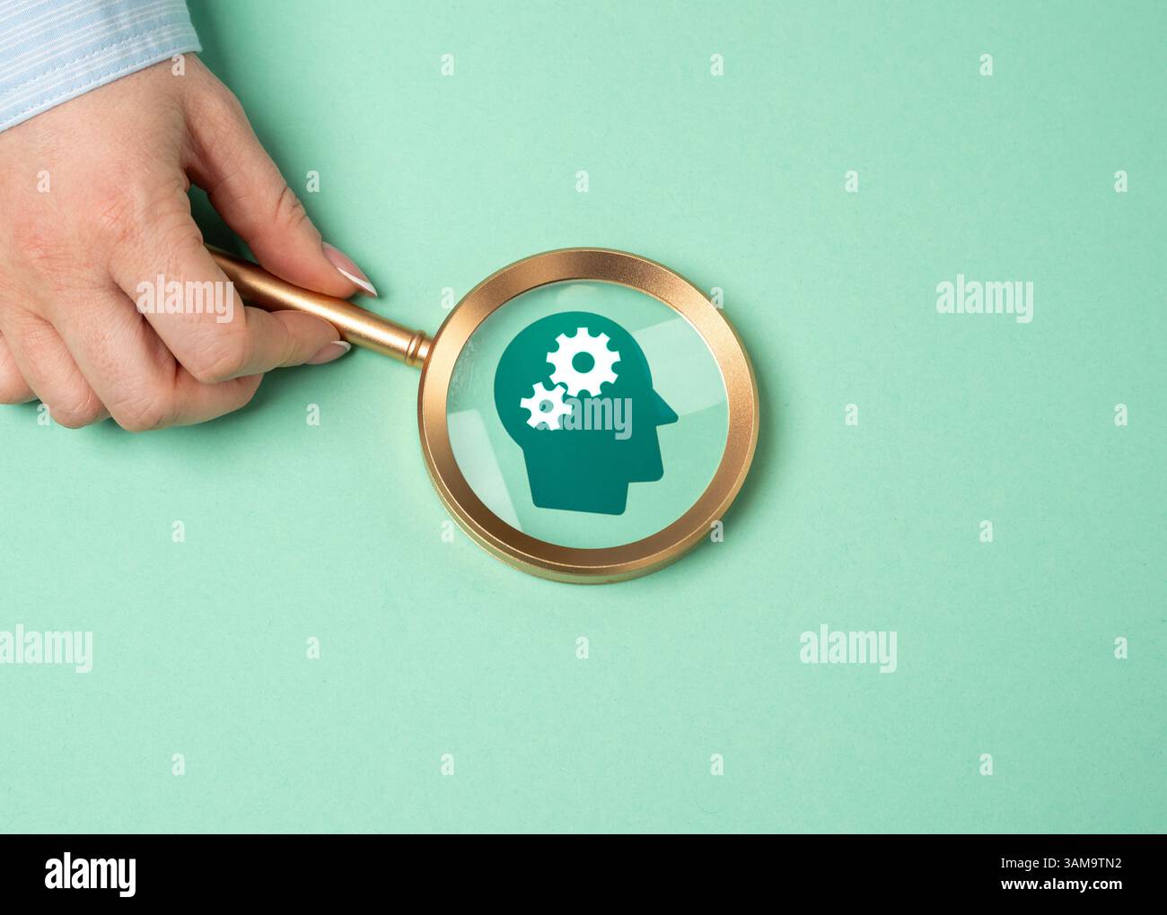 A magnifying glass points to the gears in a person's head. The concept ...