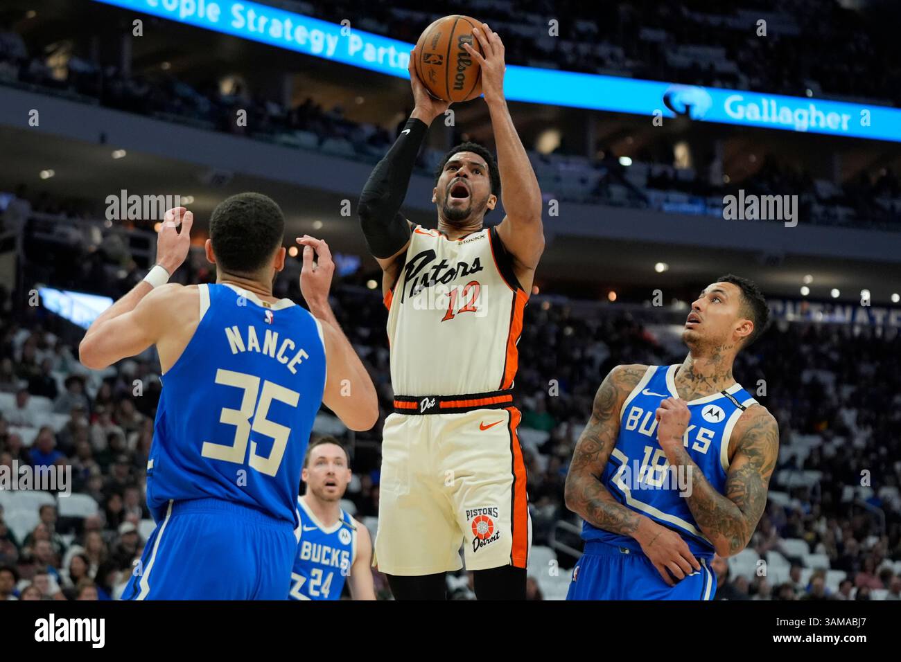 Detroit Pistons' Tobias Harris (12) shoots between Milwaukee Bucks ...