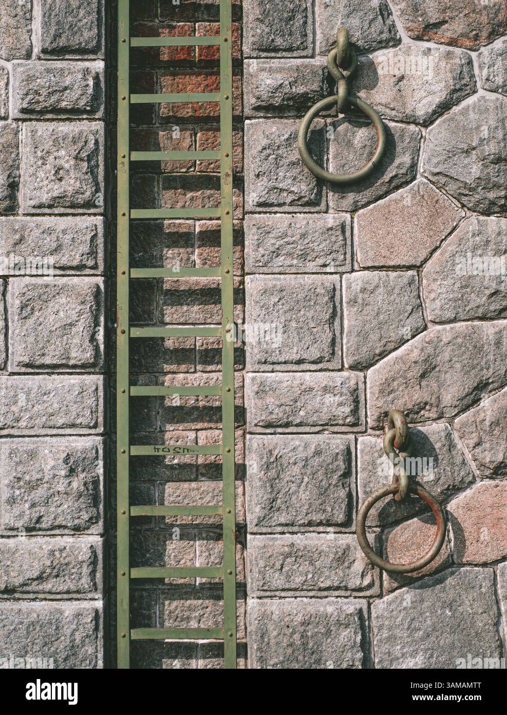 Stone Wall with Green Ladder and Mooring Rings Stock Photo - Alamy