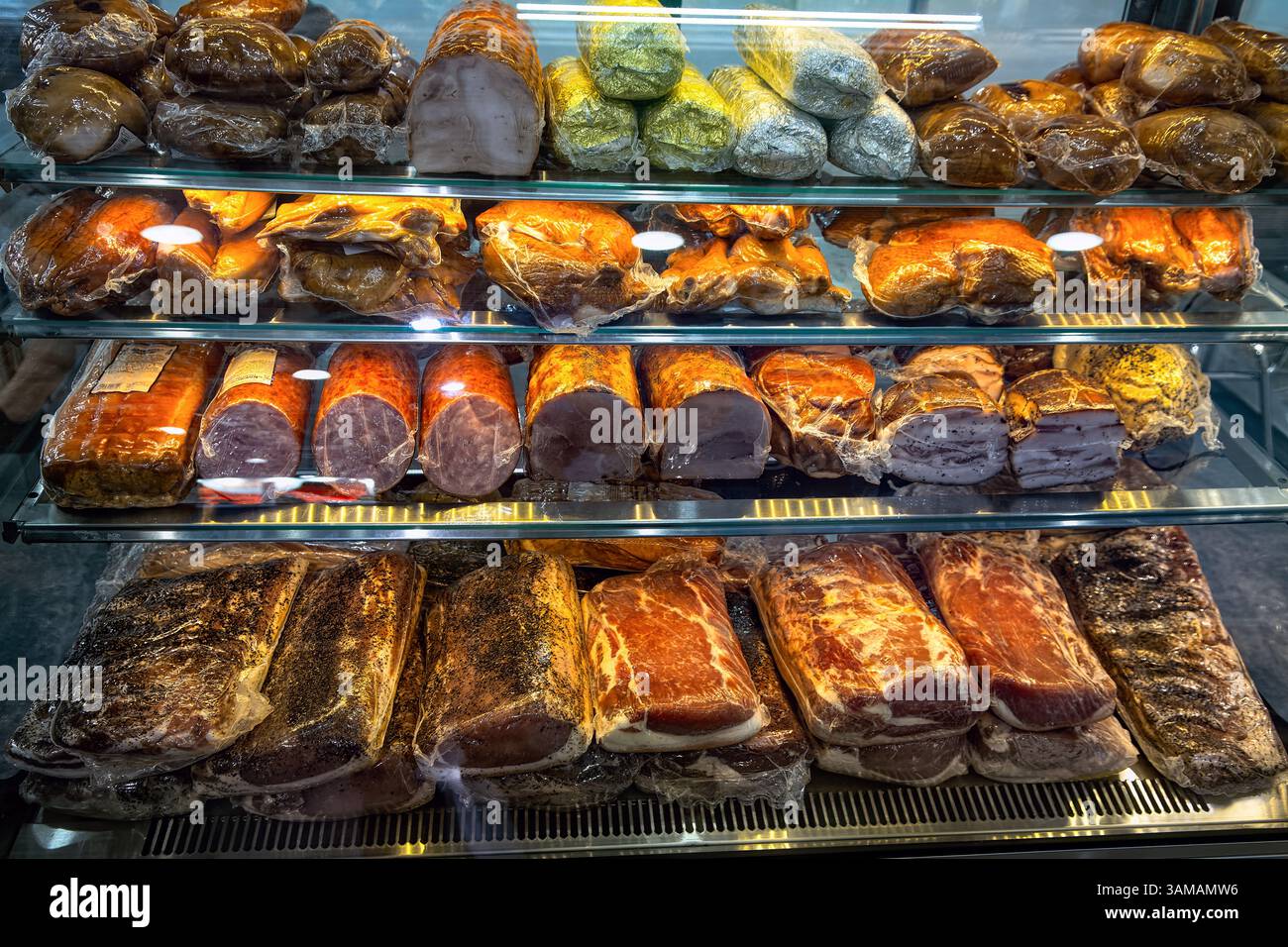 Various hams, bacons and deli meats in vacuum packaging close-up in ...