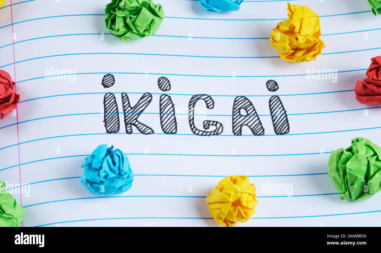 The word Ikigai written on a notebook sheet with some colorful crumpled ...