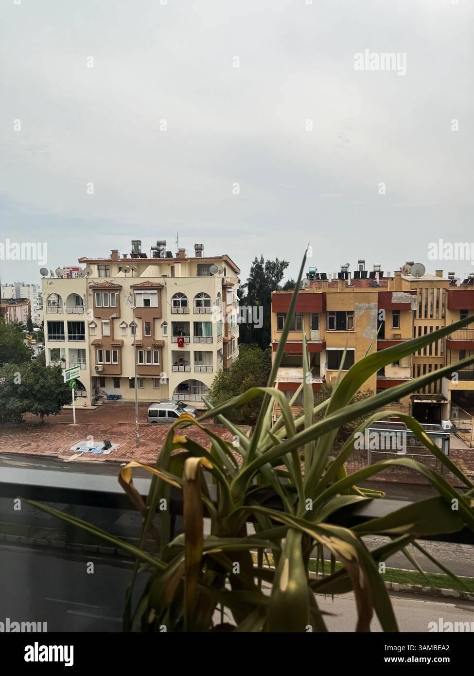 A perspective from a window reveals urban buildings with balconies and ...