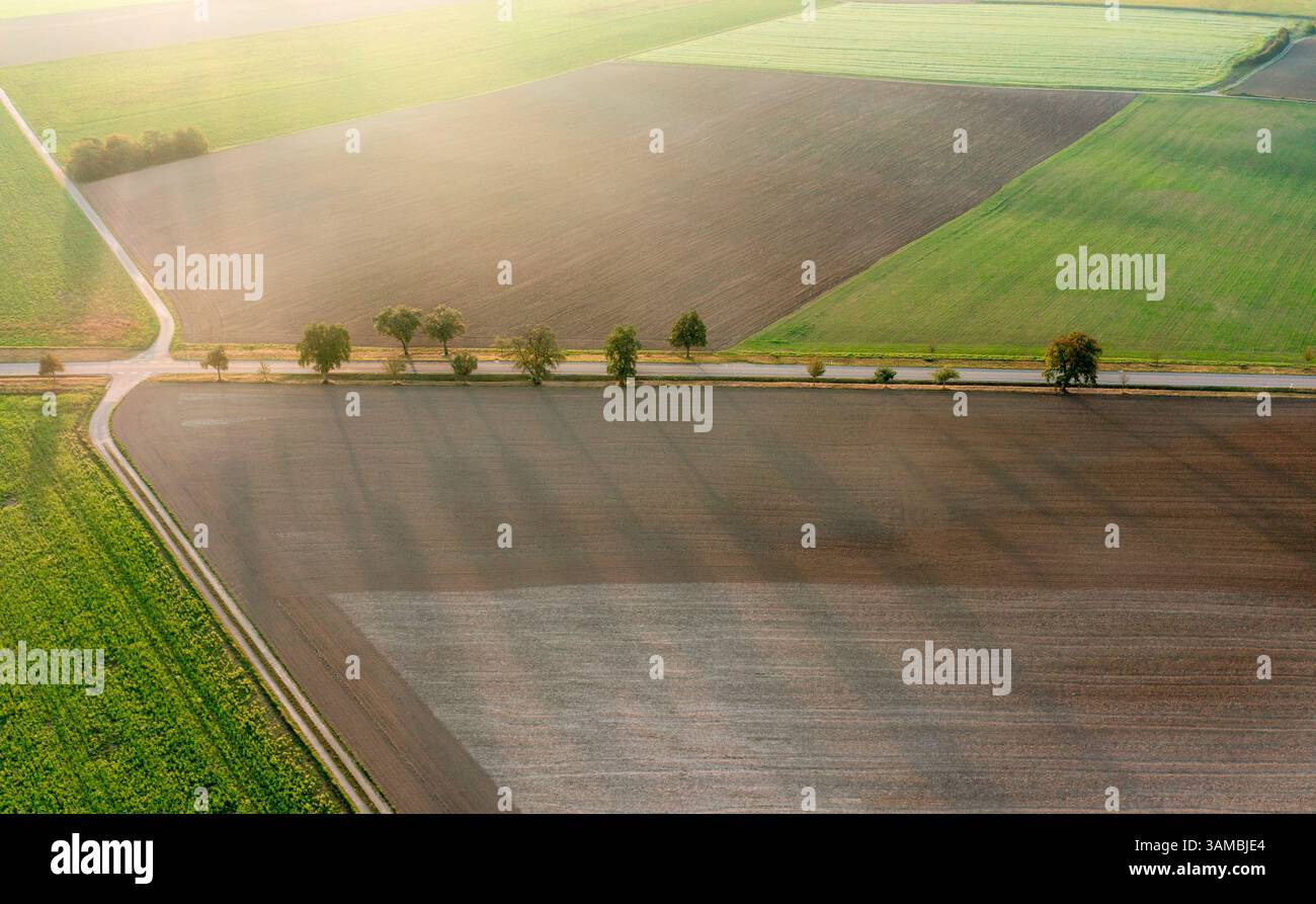 Aerial view with agricultural fields in a german village at sunrise ...