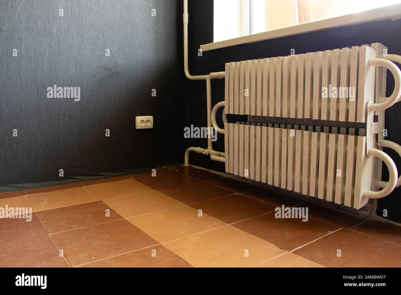 White old radiator in the apartment under the window in the bedroom and ...