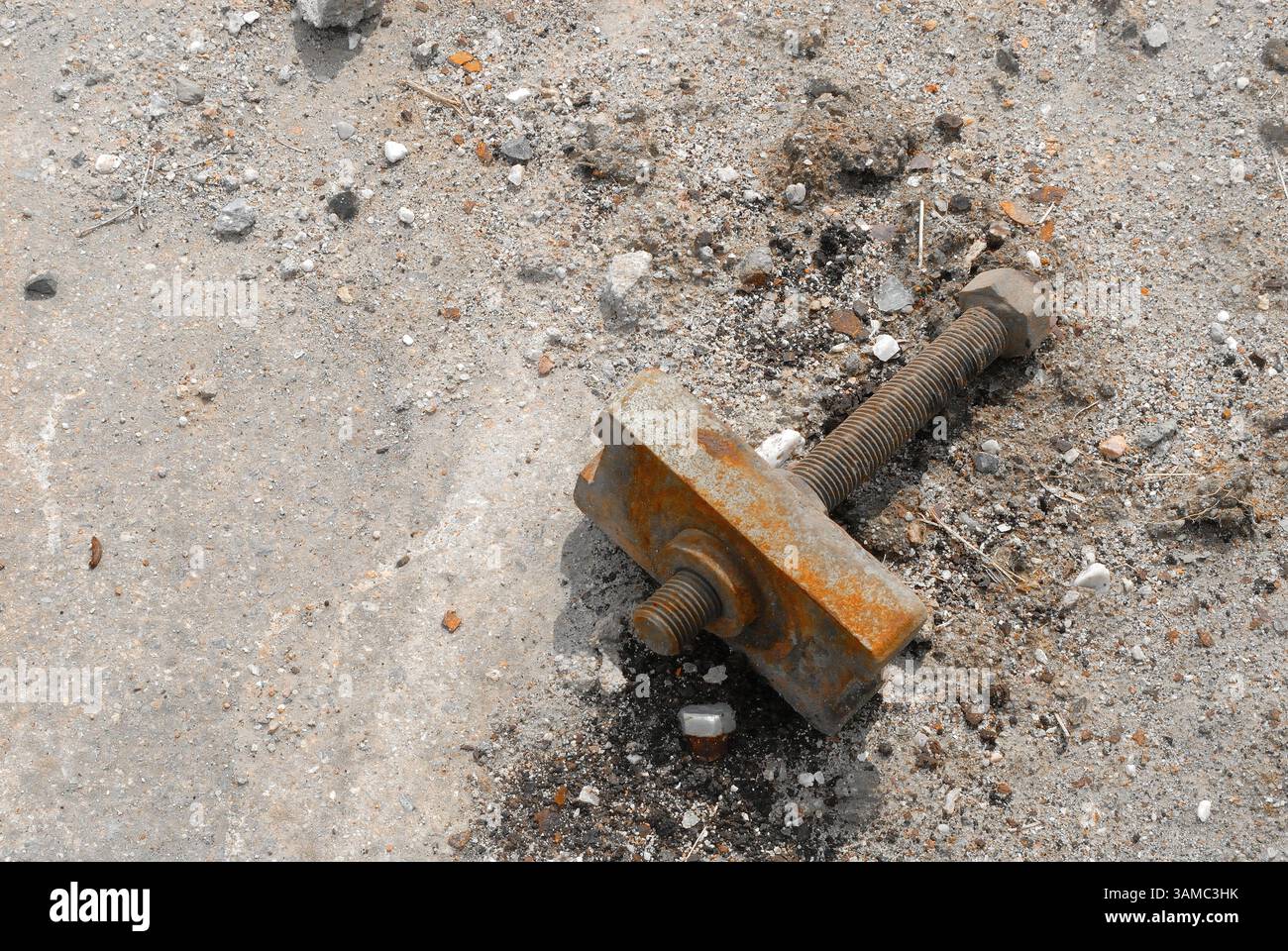 A discarded machine part lies in the gravel, rusty and marked by time ...