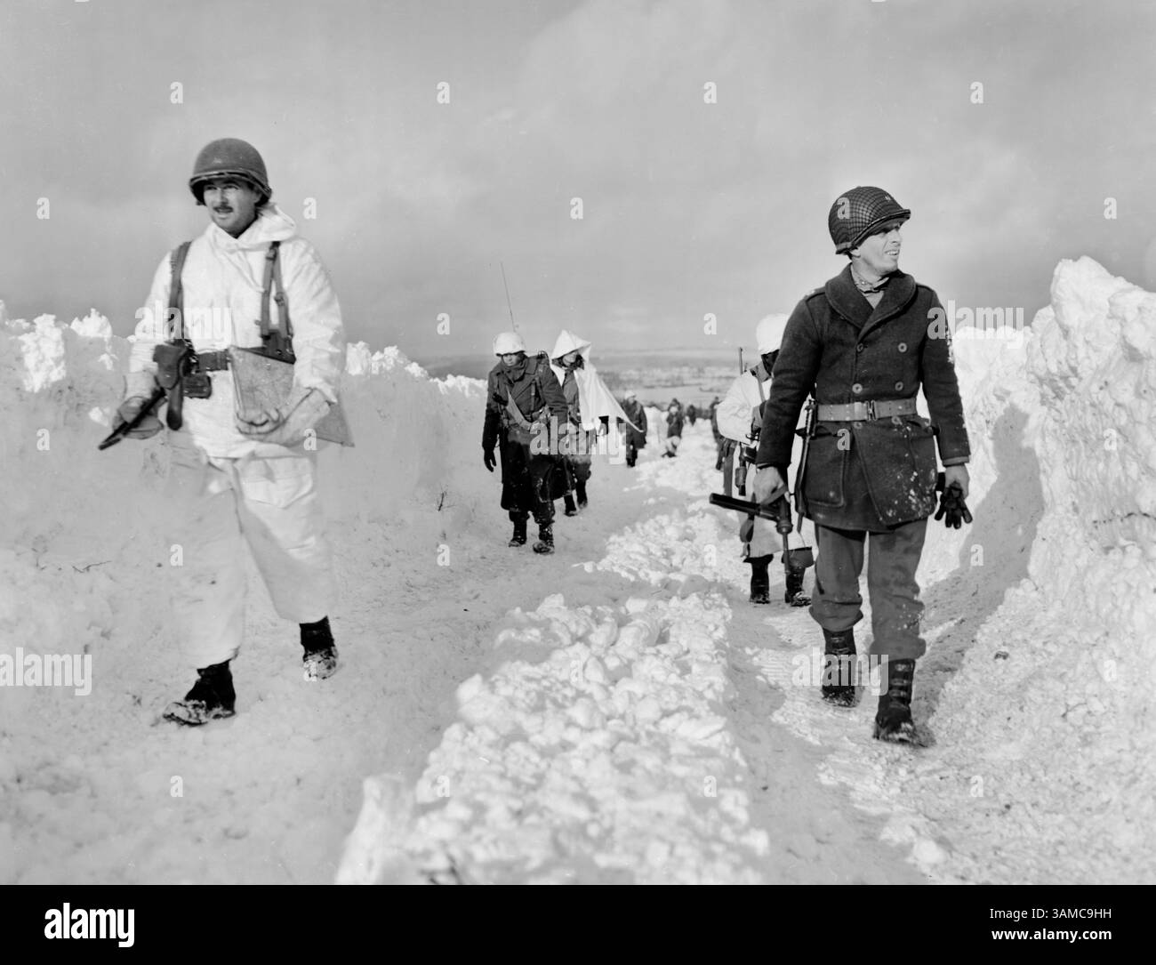 U.S. infantrymen of an armored division marching up snowy road ...