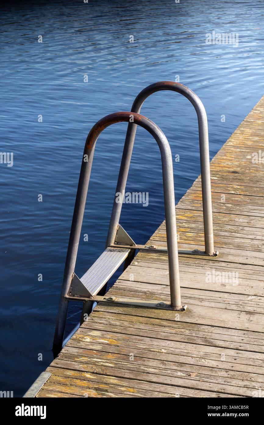 Swim ladder descending into water from wooden floating dock Stock Photo - Alamy
