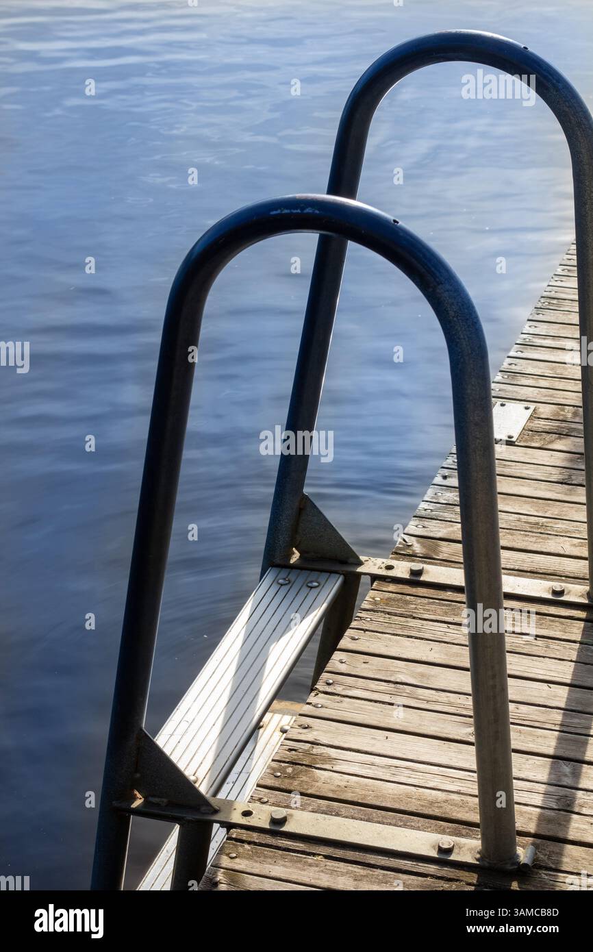 Swim ladder descending into water from wooden floating dock Stock Photo ...