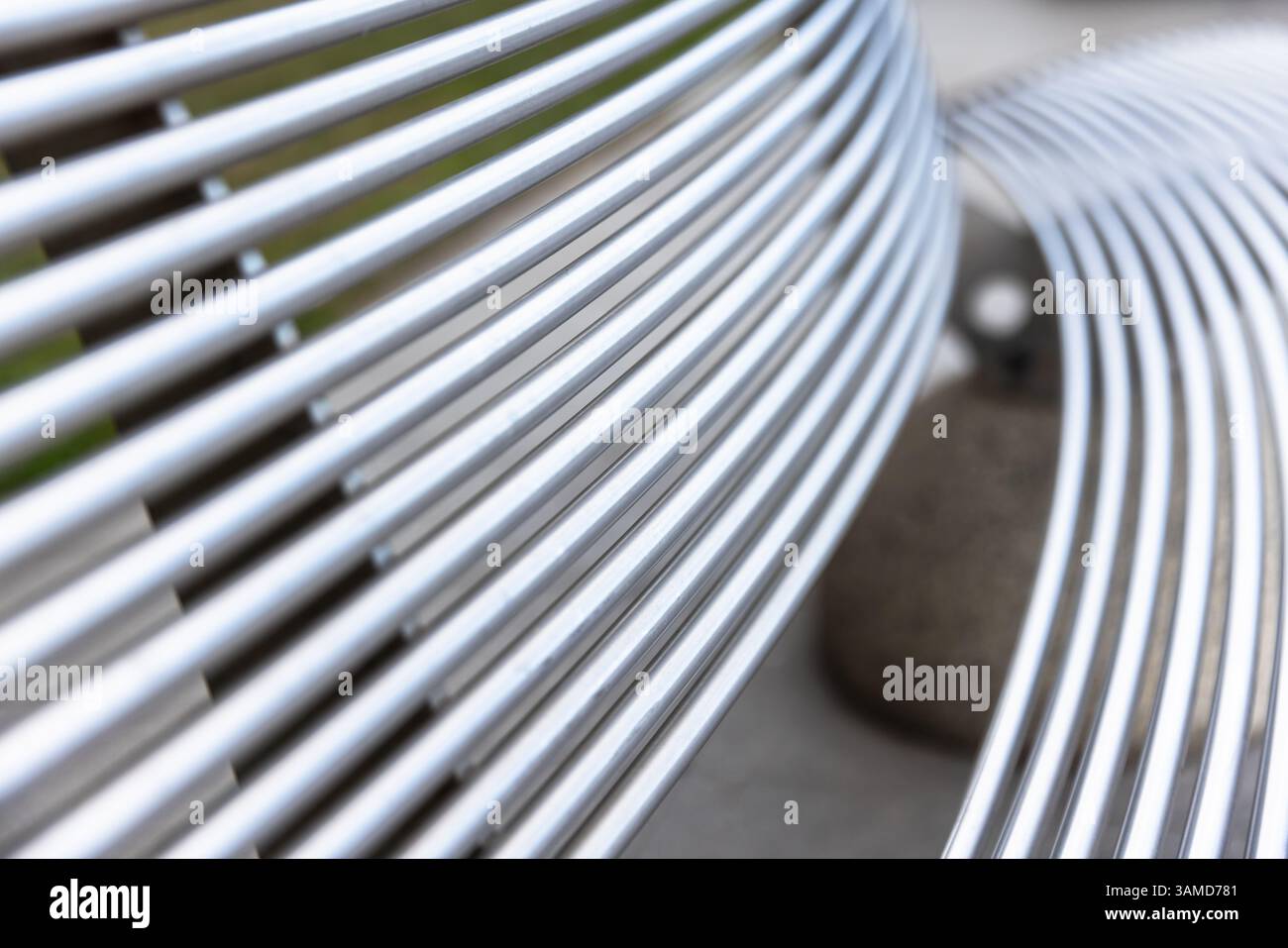 A detailed view of a metal bench featuring abstract curved striped ...