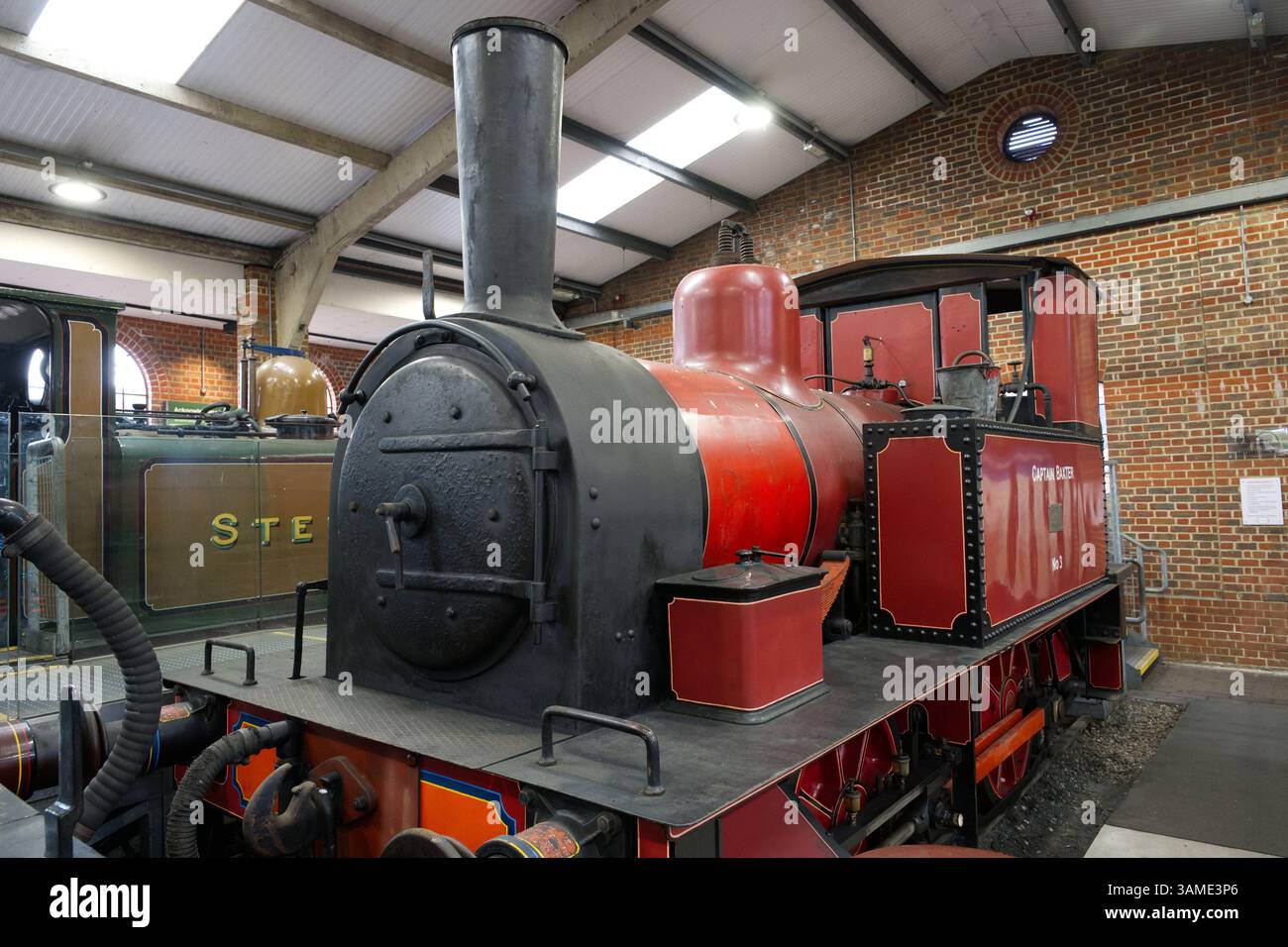 A red steam locomotive train in the engine shed at Sheffield Park ...