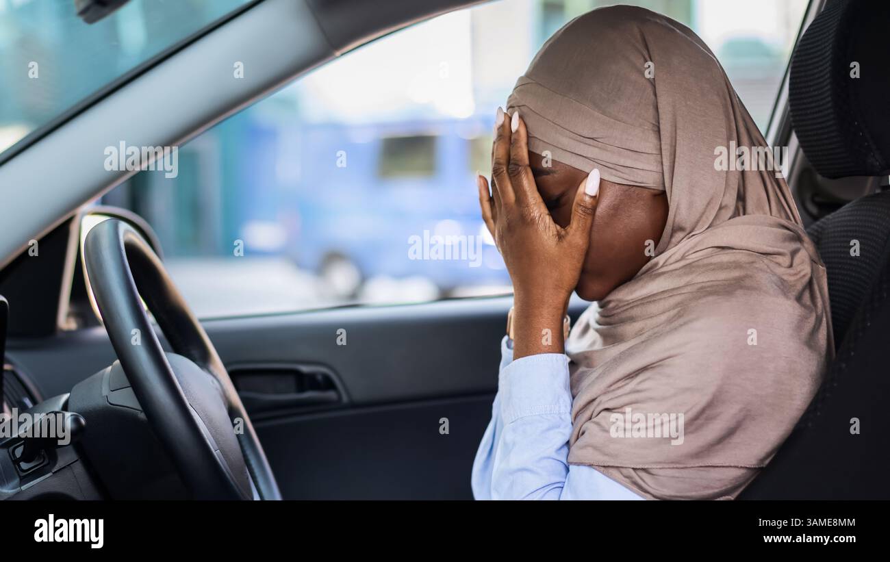 Stressed black muslim woman driver sitting in car, covering face with ...