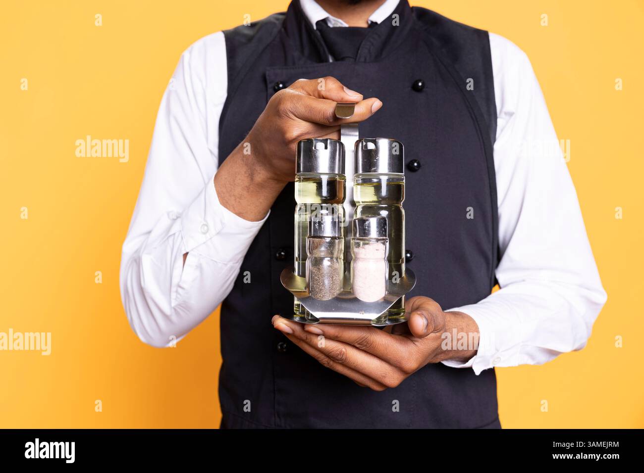 Skilled employee with a cruet set greeting clients at luxury restaurant ...