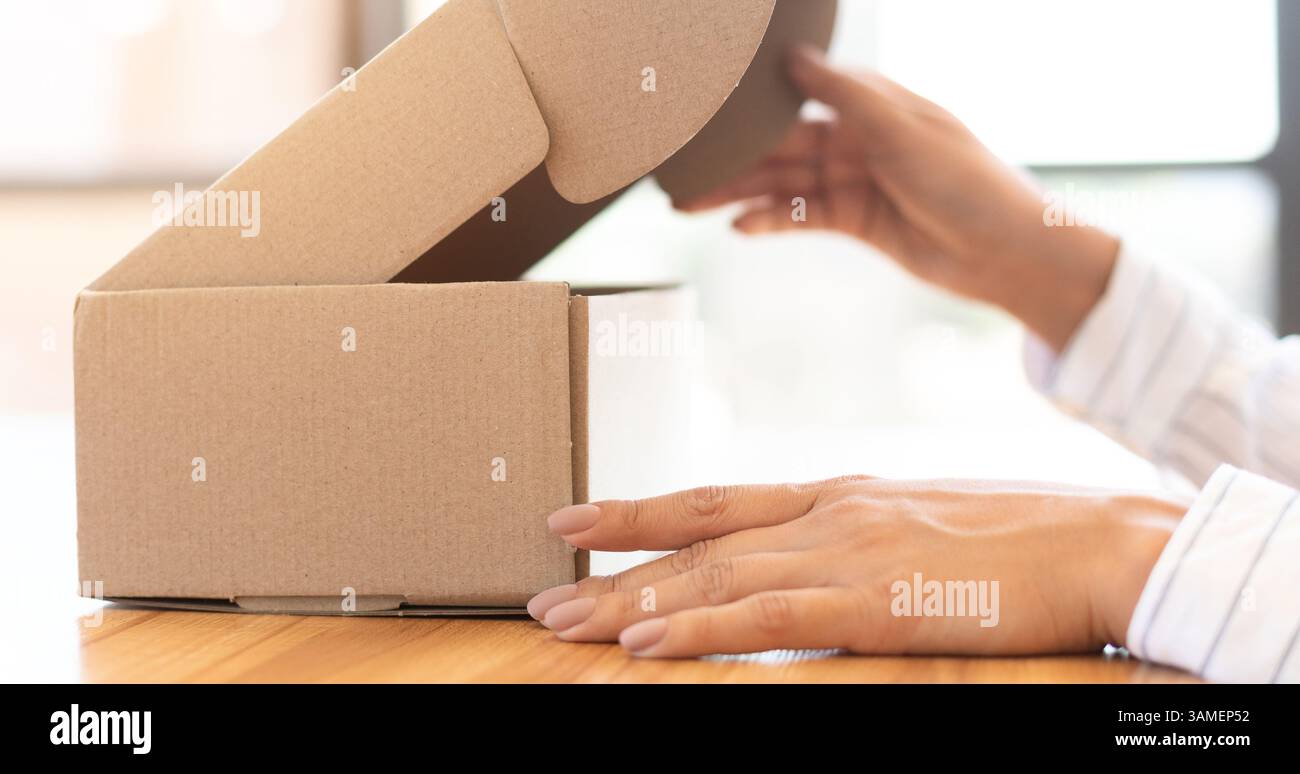Lady opening box with new parcel, close-up Stock Photo - Alamy