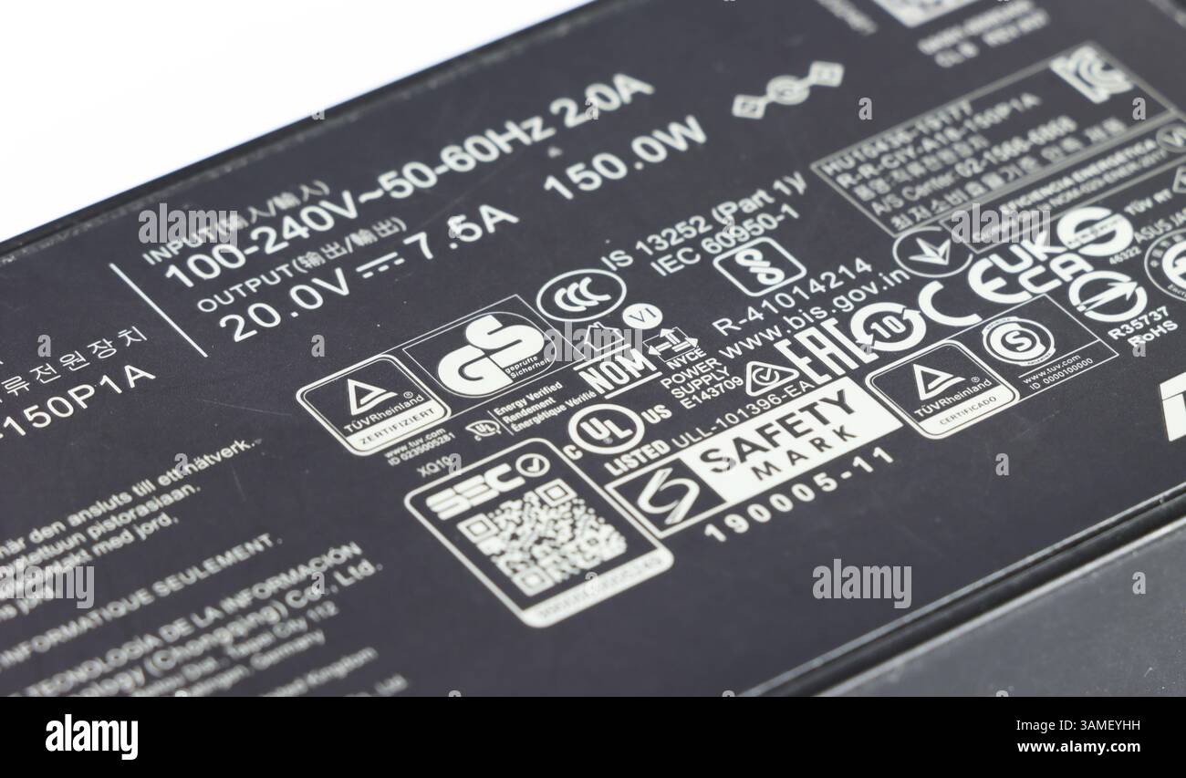 Close-up of laptop charger label with safety markings and ...