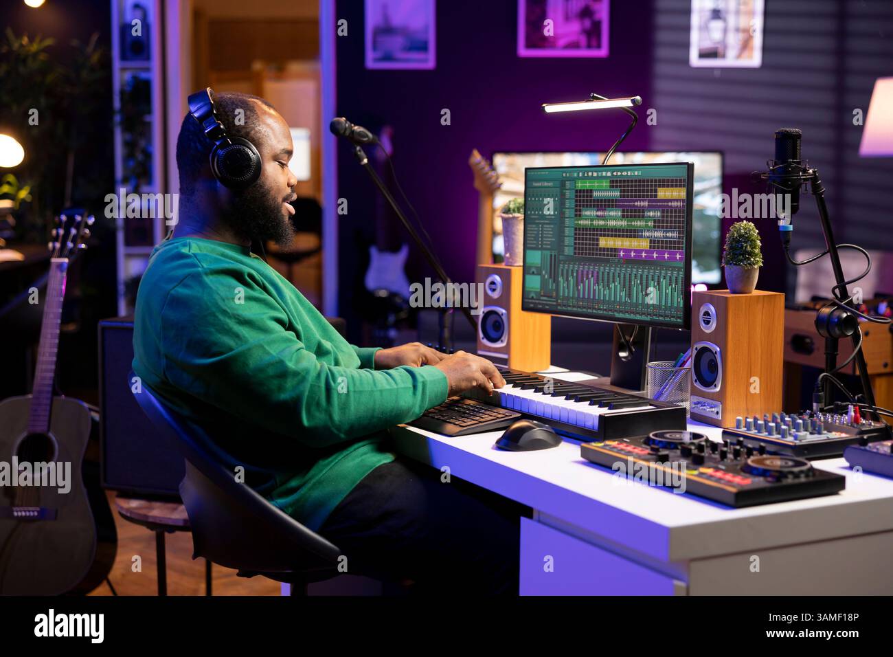Sound designer pressing keys of electronic midi controller and ...