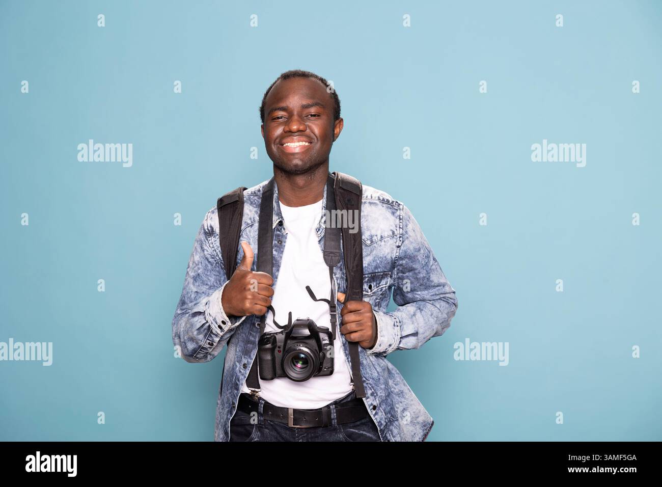 Cheerful black photographer enthusiastically gestures a thumbs up ...