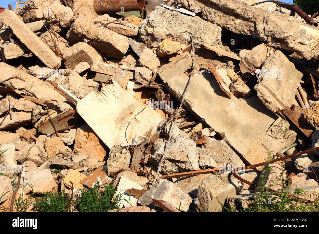 Pile of concrete rubble with exposed metal rods under sunlight Stock ...
