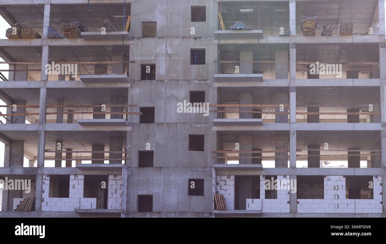 Concrete construction site with unfinished building stages and ...