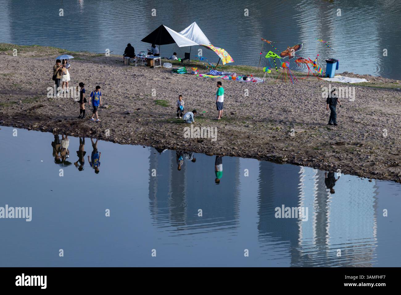 CHONGQING, CHINA - APRIL 13, 2025 - Tourists camp on Jiangxin island as ...