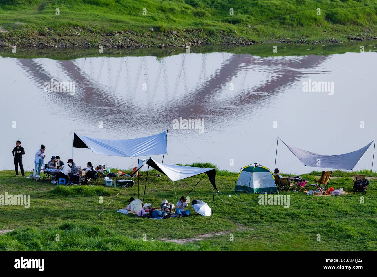 CHONGQING, CHINA - APRIL 13, 2025 - Tourists camp on Jiangxin island as ...