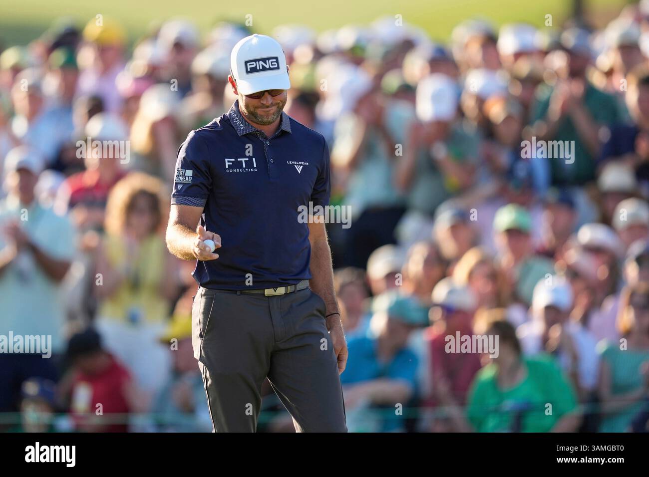 Corey Conners, of Canada, waves after making a putt on the 18th hole ...