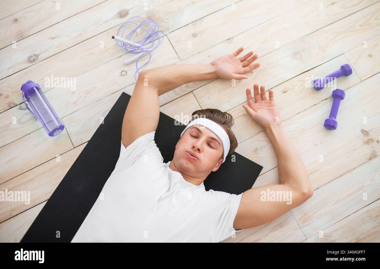 Weight loss from effective workout. Tired athlete with dumbbells and ...