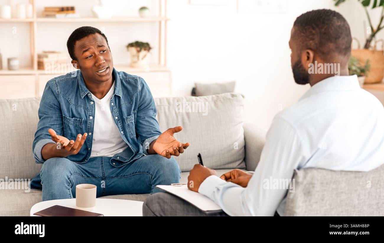 Stressed black man explaining his problems to psychologist at ...