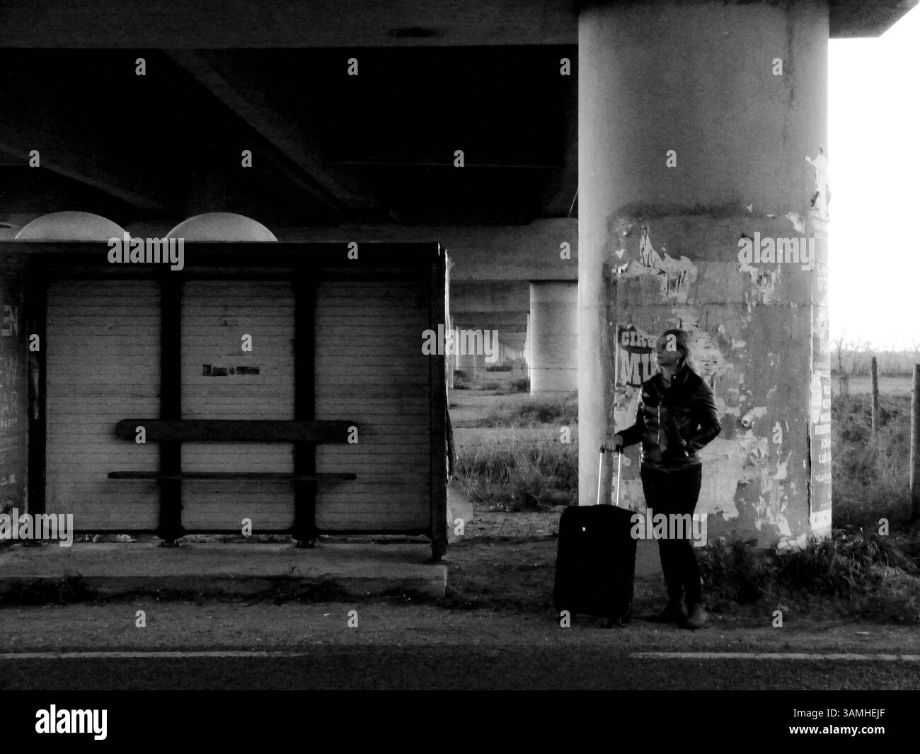 Public transport user waits for a bus at a stop under the Vasco da Gama ...