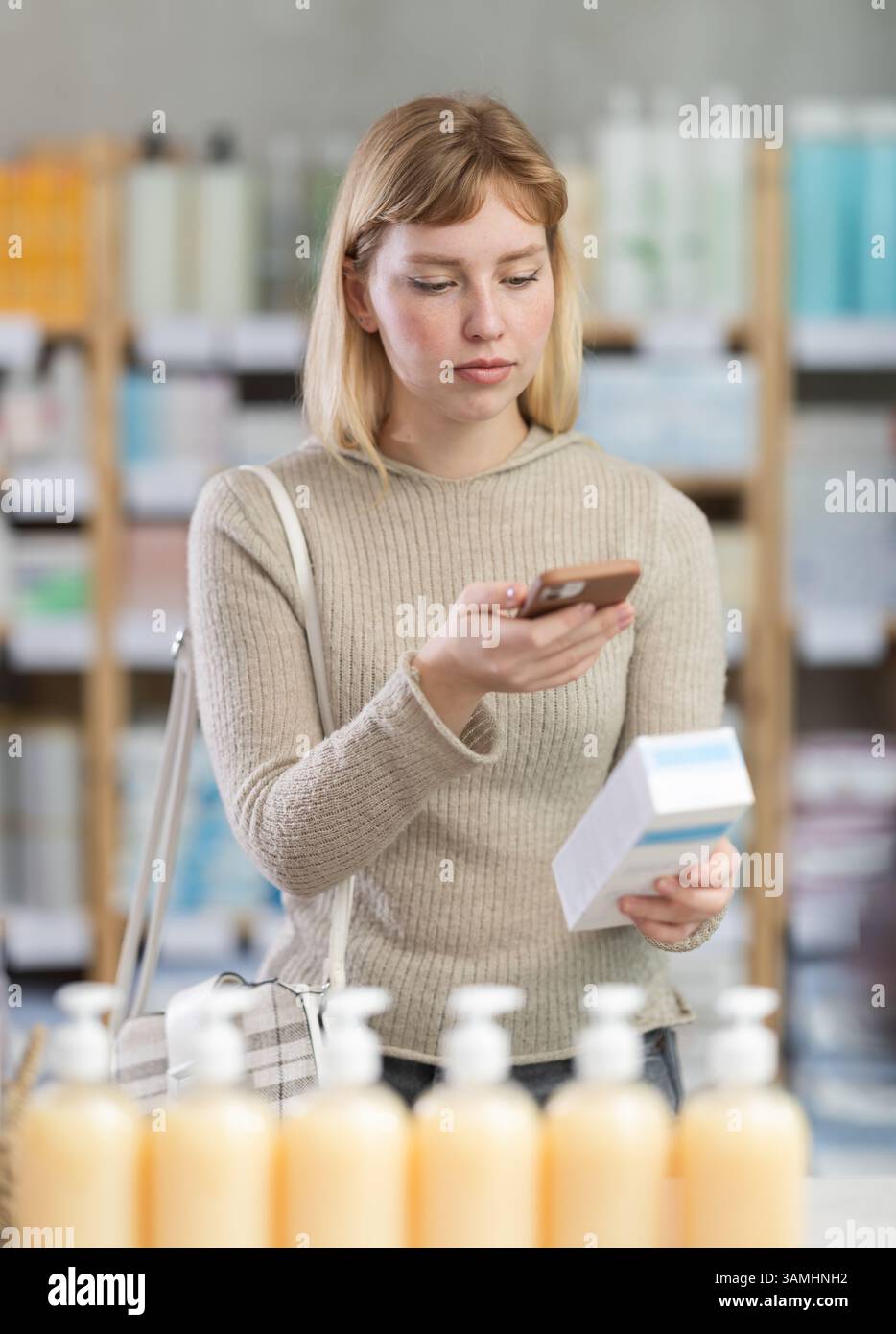 Young woman customer scanning QR-code on cream Stock Photo - Alamy