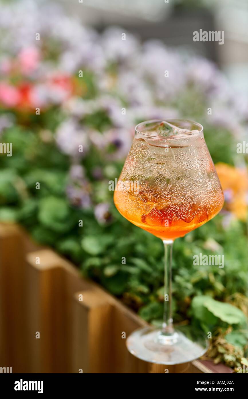 Aperol spritz cocktail in a glass with ice and flowers Stock Photo - Alamy