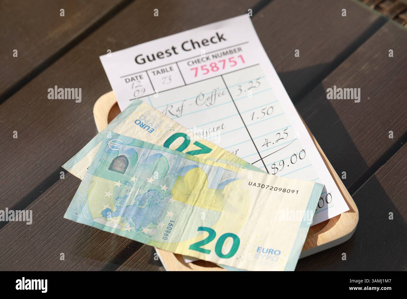Wooden plate with payment for order and receipt on table, closeup ...