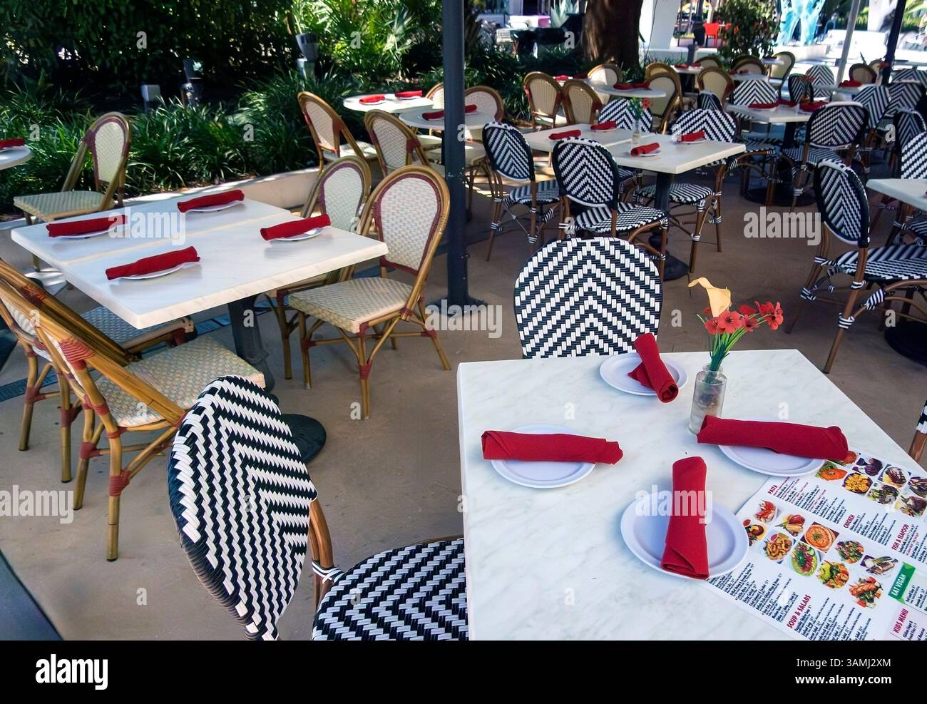 Empty restaurant tables and chairs plates napkins and pictorial menu ...
