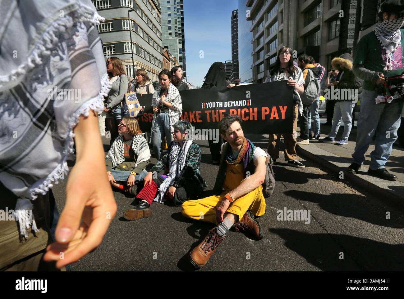 Activists sit down on the road in Aldgate High Street during the ...