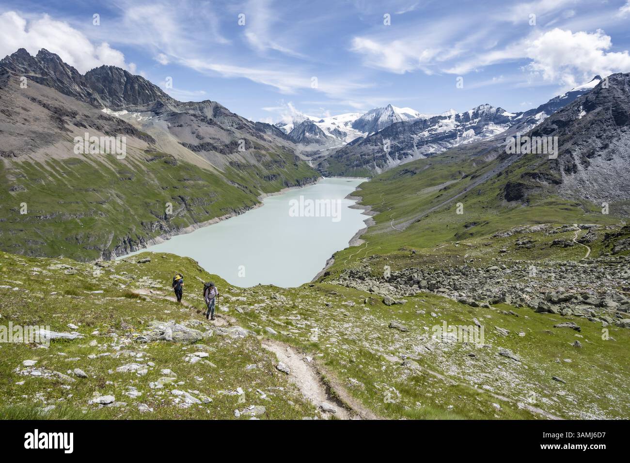 Two mountaineers on a hiking trail, view of a blue mountain lake, Lac ...
