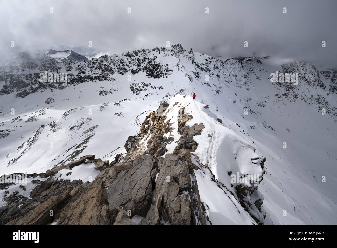 Mountaineer descending the narrow ridge of Piz Laviner, view of ...