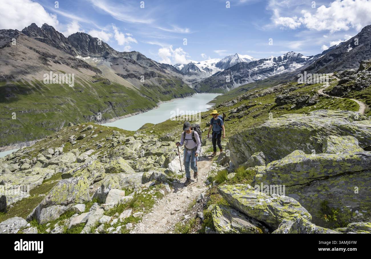 Two mountaineers on a hiking trail, view of a blue mountain lake, Lac ...