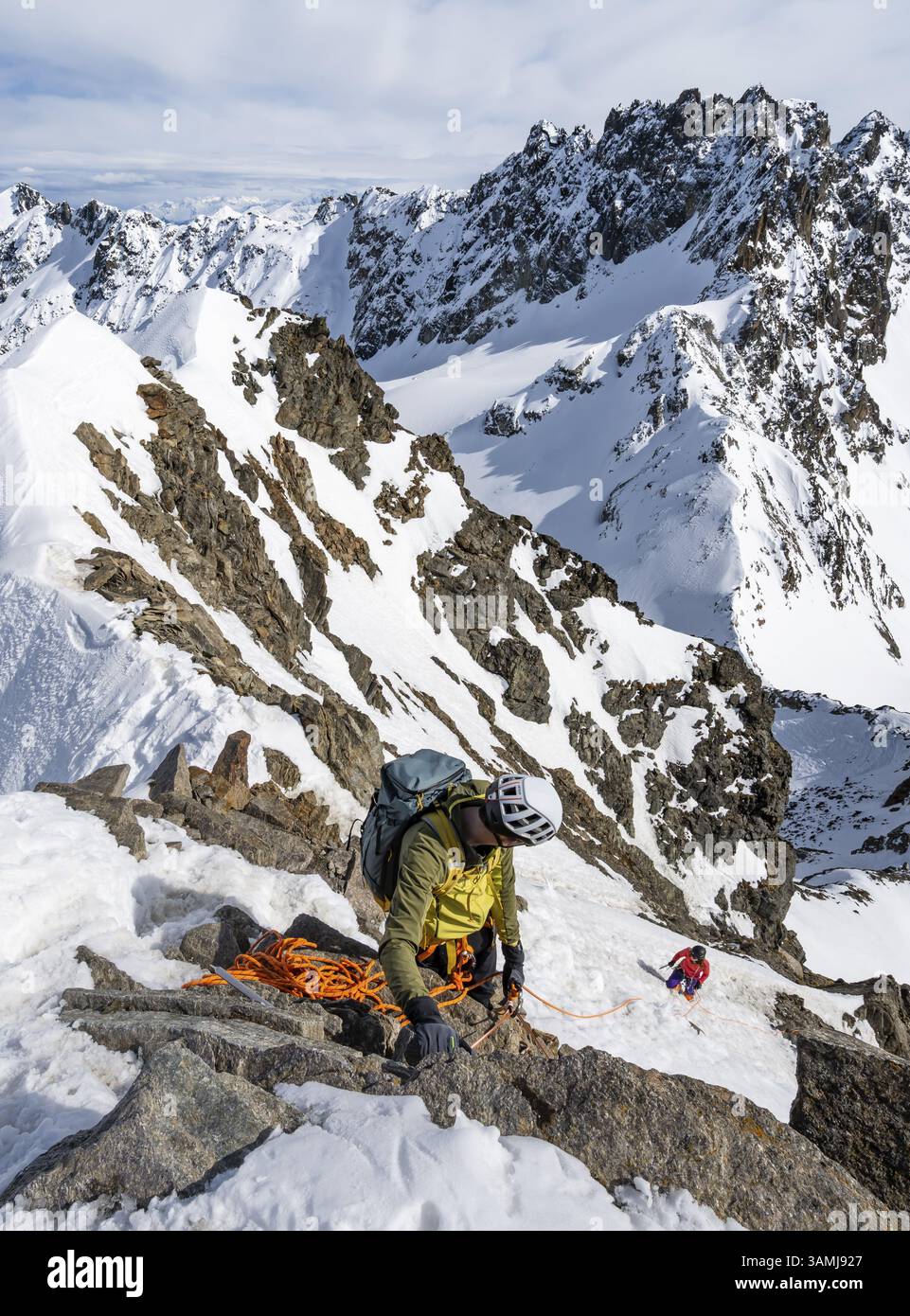 Mountaineer belaying on a steep snow slope, belaying on a rope, ascent ...