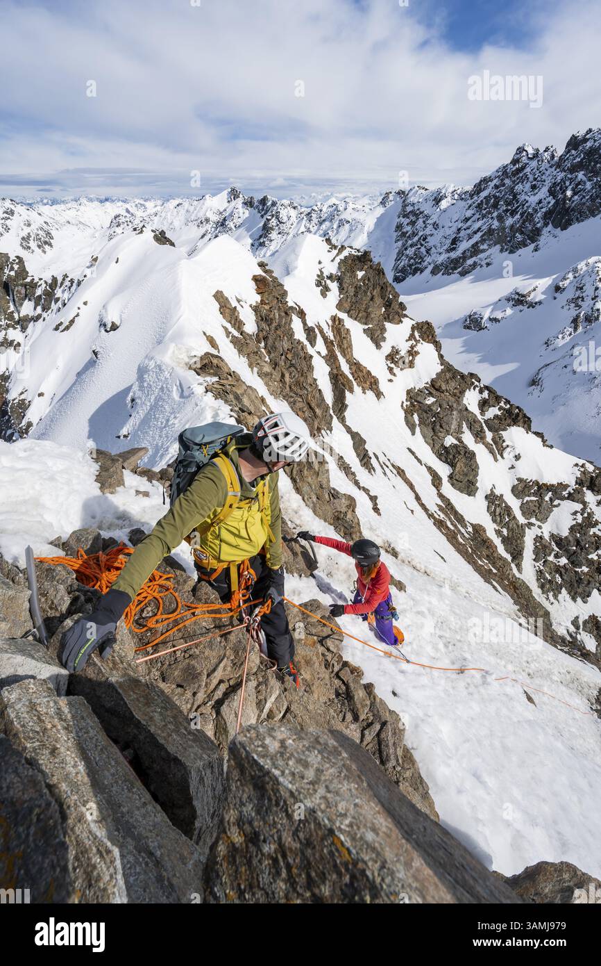 Mountaineer belaying on a steep snow slope, belaying on a rope, ascent ...