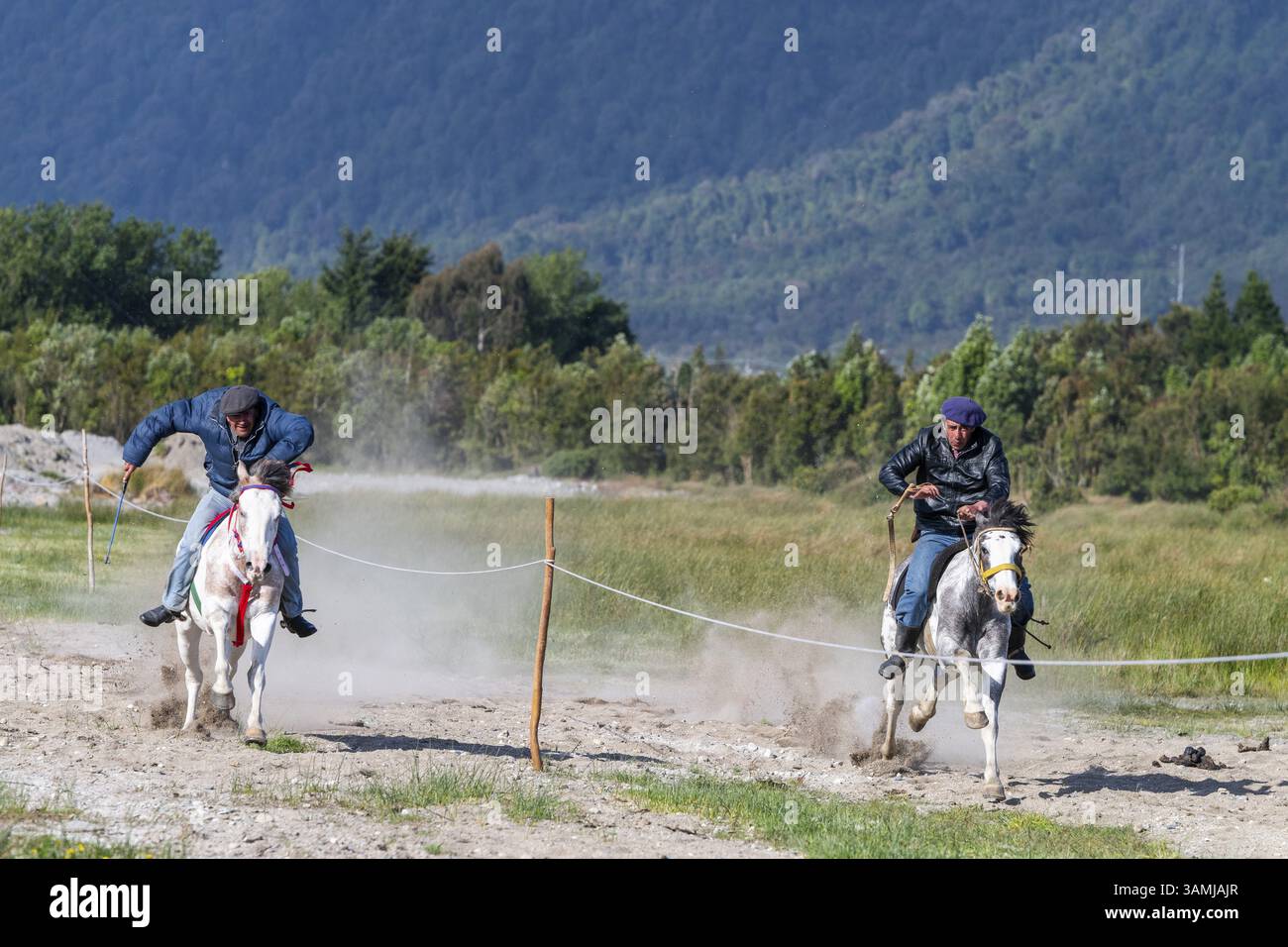 Two men galloping side by side on their horses at a gaucho horse race ...