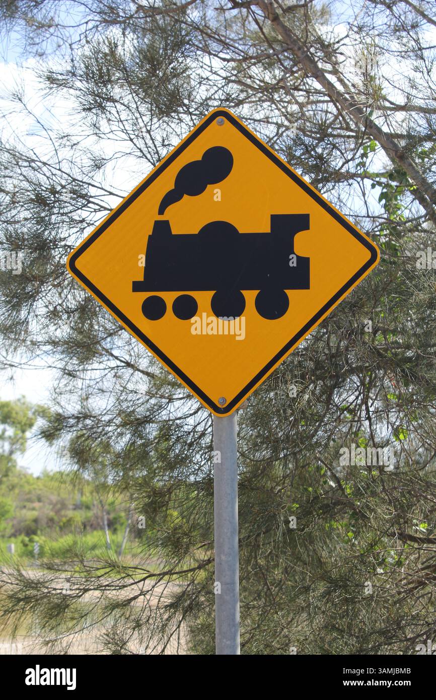 Yellow diamond-shaped railway crossing road sign with a black icon of a ...